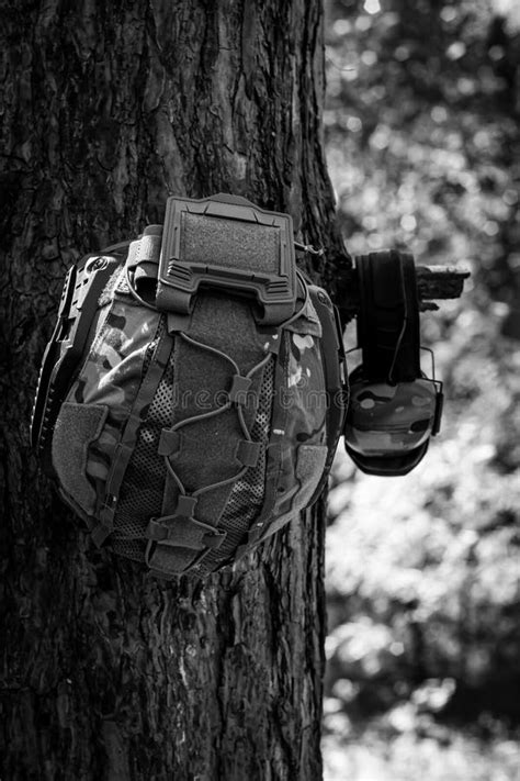 Camouflage Patterned Military Tactical Helmet Hangs On A Tree Branch In
