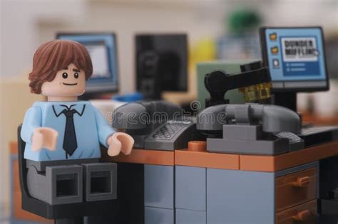 A Lego Businessman Minifigure Sitting On A Chair Behind A Computer In An Office Editorial