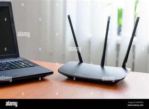 Wireless Wifi Router And Laptop At Wooden Table Indoors Window Behind Wireless Connection