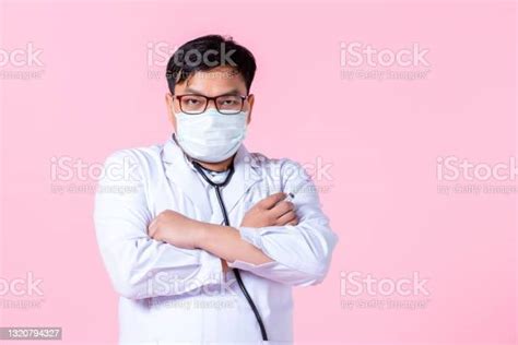 아시아 남자 의사 치료청진기는 팔을 접고 분홍색 빈 복사 공간에 고립 된 카메라를보고 측면 눈에 주사기를 들고 긍정적 인 감정으로 조언 20 29세에 대한 스톡 사진 및