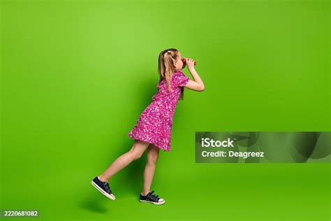 빨간 장난감을 들고 눈에 띄는 역동적인 포즈를 취하면서 단단한 녹색 배경에서 장난기 넘치는 순간을 즐기는 사랑스러운 어린 소녀 8 9 살에 대한 스톡 사진 및 기타 이미지