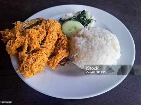 나시 아얌 고렝 크림 또는 쌀 바삭한 양념 플레이크 쌀 얇게 썬 오이 양배추 및 삶은 카사바 잎을 곁들인 바삭한 프라이드 치킨 음식 메뉴 0명에 대한 스톡 사진 및 기타