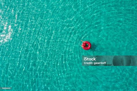 세이셸의 투명한 청록색 바다에서 수영 링 도넛에서 수영하는 슬림 한 여성의 공중 보기 소녀와 여름 바다 풍경 아름다운 파도 다채로운 물 드론에서 보기 공중 뷰에 대한 스톡