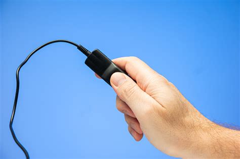 백인 남성 손을 잡고 파란색 배경에 고립 된 케이블 유선 검은 색 플라스틱 원격 제어 장치를 누르고 Brand Name Video Game에 대한 스톡 사진 및 기타 이미지