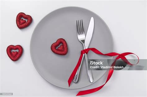 발렌타인 데이 축제 테이블 설정 흰색 테이블에 회색 접시 포크 칼과 빨간색 리본에 빨간 하트 모양평면 누워 데이트 컨셉을 좋아합니다 텍스트를 배치하고 공간을 복사합니다 0
