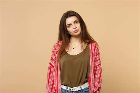 캐주얼 서 서와 스튜디오에서 파스텔 베이 지 배경에 고립 된 찾고 카메라를 보고 잠겨있는 불쾌 한 젊은 여자의 초상화 사람들은 진심으로 감정 라이프 스타일 개념입니다 복사