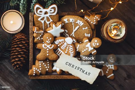 빈티지 나무 상자에 담긴 전통적인 휴일 수제 진저 브레드 쿠키 크리스마스 단어가 적힌 종이를 만드세요 축제 분위기 아늑한 가정 분위기 수제 장난감 전나무 가지 요정 조명 0