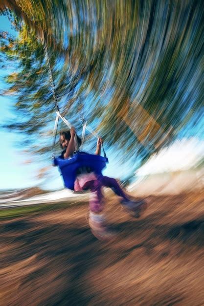 Premium Photo Blurred Motion Of Girl Swinging On Swing At Park