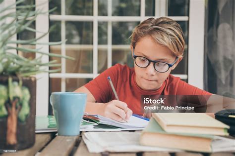 야외에 앉아 집에서 숙제를하고있는 젊은 학생 소년 쓰기와 학교 책과 신문공부 아이는 연구를하고 카피 북에 쓰기 교육 새로운 기술 라이프 스타일 개념 공부에 대한 스톡 사진