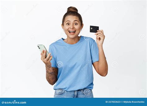Fille Excitée Tenant Carte De Crédit Et Téléphone Mobile Payant Avec L