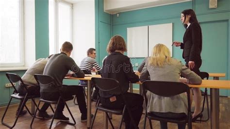 Woman Teacher Check Students Progress During A Lesson In Classroom