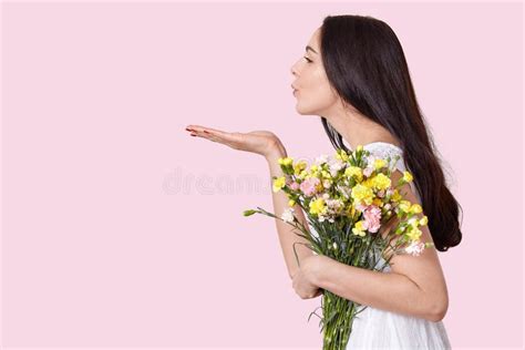 Profile Shot Of Brunette European Woman Blows Air Kiss Stretches Palm