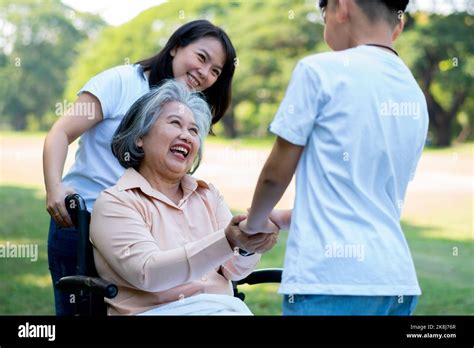 Une Grand Mère Asiatique Heureuse Utilise Un Fauteuil Roulant Avec Sa