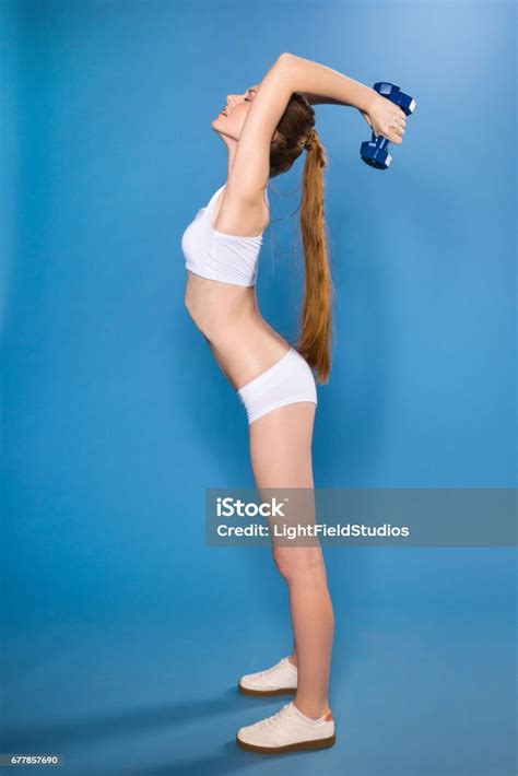 스튜디오에서 파란색에 고립 된 아령과 젊은 스포츠 우먼 훈련 건강한 생활방식에 대한 스톡 사진 및 기타 이미지 건강한 생활방식 근육질 체격 덤벨 Istock