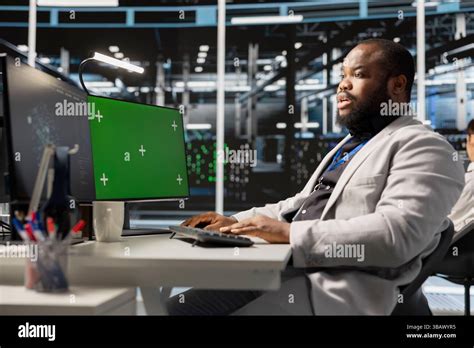 data center technician inspecting gear using green screen mockup pc doing maintenance tasks