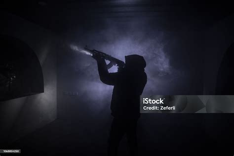 소총 어두운 톤된 안개 배경 또는 검은 발라 클 라바 손에 들고 총 입고 위험한 산적에 공격을 준비와 남자의 실루엣 테러 무기 테마 장식으로 촬영 테러리즘에 대한 스톡 사진