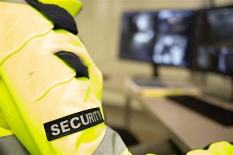 Premium Photo Security Officer With A Yellow Jacket Sitting At The Office In Front Of The Computer