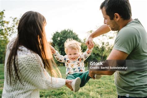 행복한 어머니 아버지는 해질녘 하늘에 아기를 던집니다 야외에서 함께 시간을 보내는 가족 부모가 들판의 풀밭에서 놀고 있는 행복을 가진 아이 평면도 어린이날 친절한 가족 18