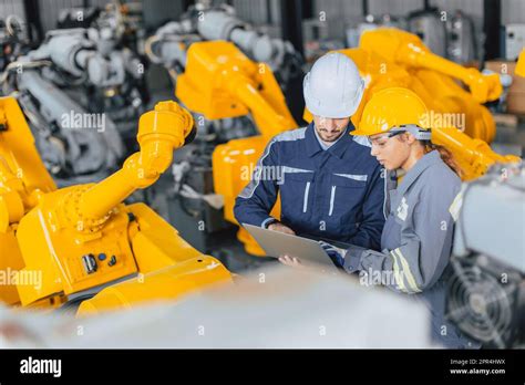 Engineer Team Working Together Inspection Quality Robot Arm In Robot Assembly Industry Plant