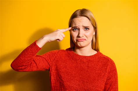 클로즈업 초상화 그녀의 그녀의 좋은 찾고 매력적인 사랑 스러운 슬픈 우울한 기분을 상하게 소녀는 밝은 생생한 광택 오렌지 배경 위에 고립 된 눈 썹 사원의 집게 손가락을