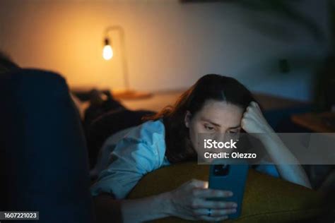 소파에 누워 집에서 밤에 스마트폰 화면을 보고 있는 젊은 진지한 슬픈 여자 전화에 대한 스톡 사진 및 기타 이미지 전화 밤