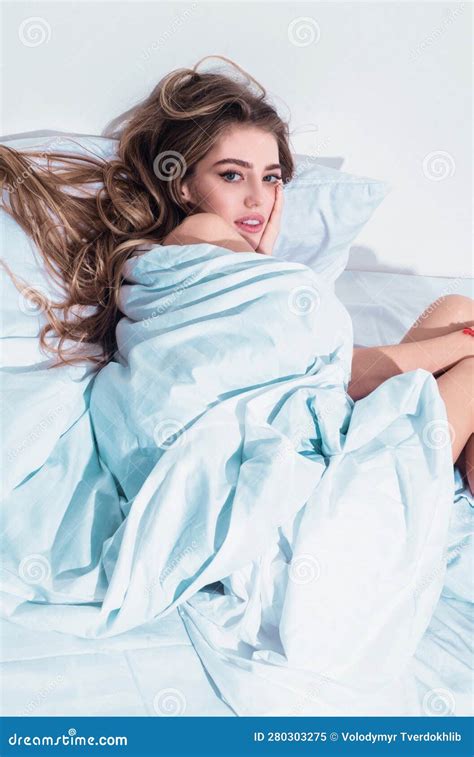 Sensual Woman Lying In Bed And Hiding Under The Sheet Stock Image