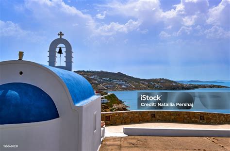 여름날에는 전형적인 그리스 해안 또는 섬 풍경에 파란색 돔과 종탑이 있는 전통적인 그리스 정교회 만을 항해하는 범선 미코노스에