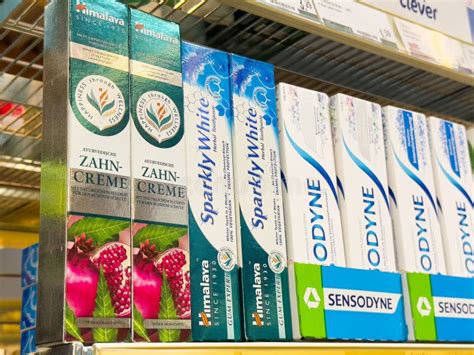Variety Of Toothpaste Brands Displayed On Supermarket Shelf In Dental