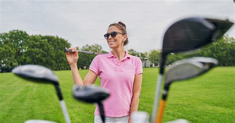 골프 연습장에 서 있는 어깨에 골프채를 메고 웃고 있는 스포티한 아가씨 사진 Unsplash의 골프 이미지