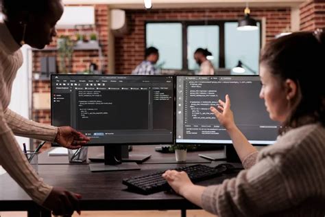 Multi Ethnic Tech Enginners Developing Html Code And Cloud Computing In