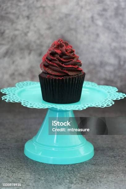 개별 수제 초콜릿 컵케이크 브라운 청록색 케이크 스탠드의 종이 케이크 케이스 탈수 된 라즈베리 먼지 회색 배경으로 코팅 된 초콜릿 버터 착빙 파이프 소용돌이의 이미지 전경에