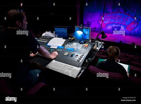 A Man Operating A Digital Lighting Desk Board In A Theatre Designing