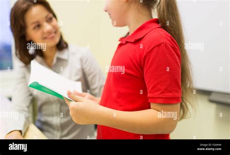 Babe Girl With Notebook And Teacher In Classroom Stock Photo Alamy