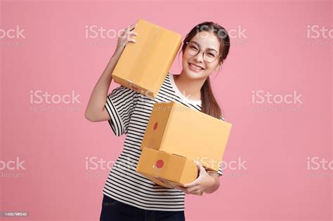 분홍색 배경에 고립 된 소포 상자를 들고있는 아름다운 젊은 아시아 여성 배달 택배 및 배송 서비스 개념 25 29세에 대한 스톡 사진 및 기타 이미지 Istock
