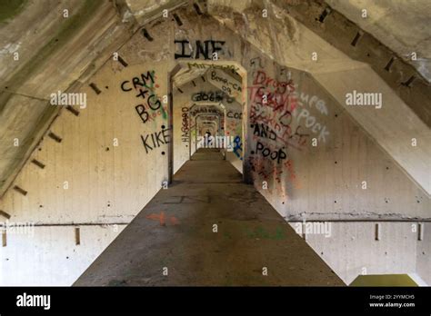 A Long Narrow Tunnel With Graffiti On The Walls The Graffiti Includes Words Like Kike And