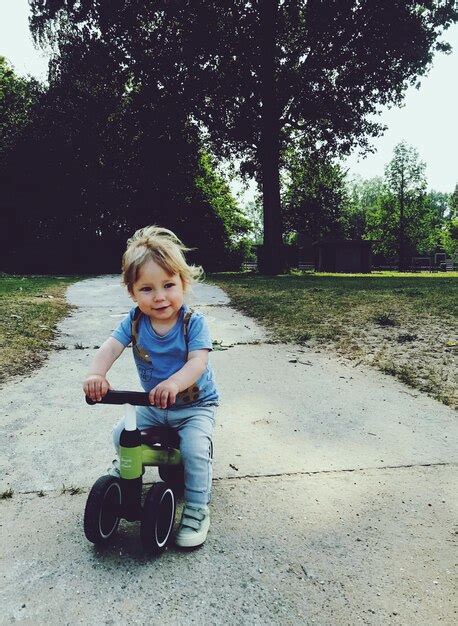 Premium Photo Portrait Of Cute Boy Riding Push Bysicle On Road