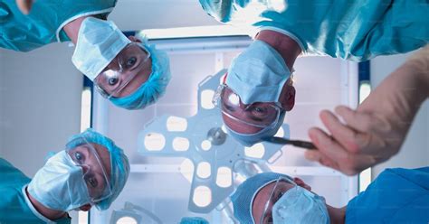 파란색 수술복을 입은 외과 의사 그룹이 수술을 하고 있습니다 사진 Unsplash의 수술실 이미지