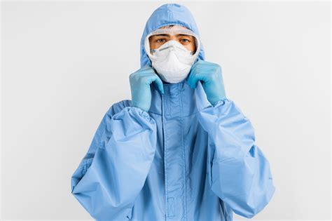 코로나바이러스에 대한 보호복을 입은 남성 의사는 의료용 마스크 안경 장갑을 착용하고 팔을 흰색 배경에 두어 두어 갔다 검역