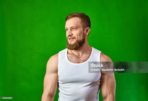 수염을 기르는 잘생긴 남자의 초상화가 옆으로 보입니다 녹색 배경 복사 공간 장소에 자신감 있는 사람 텍스트 보디빌더는 행운과 기쁨을 보았습니다 행복한 백인 남자 긍정적인