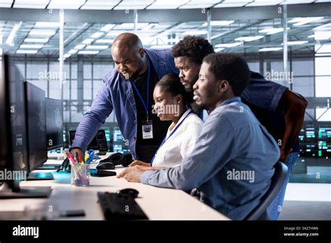 Group Of Technicians Doing Brainstorming Reconfiguring Server Farm To Optimize It For Data