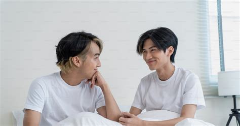 아시아 잘 생긴 게이 커플의 초상화는 집에서 침실의 침대에 앉아 있습니다 매력적인 낭만적 인 남성 Lgbt 커플은 아침 자유 시간을 함께 보내고 미소를 지으며 집에서