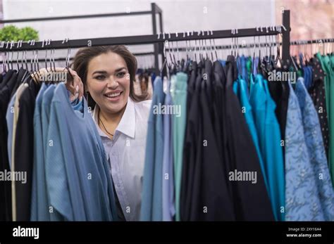 A Smiling Fat Woman In A Plus Size Store Chooses Clothes While Sorting