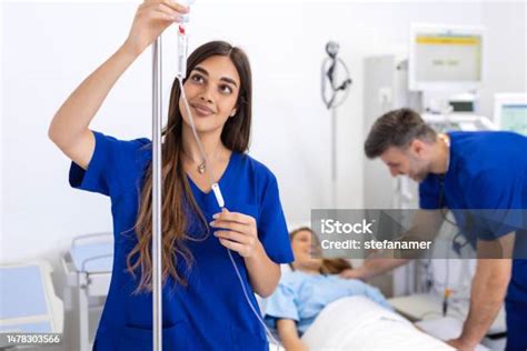 파란 가운을 입은 젊은 여성 의사 마취과 의사가 Iv 스포이드를 병실에 넣습니다 간호사에 대한 스톡 사진 및 기타 이미지 간호사 개념 개념과 주제 Istock