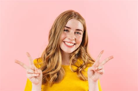 Premium Photo A Cheerful Optimistic Cute Girl Isolated Over Pink Wall Showing Peace Gesture