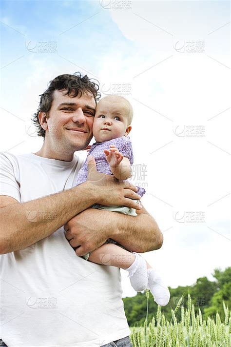 快乐的父亲和婴儿在农村的田野