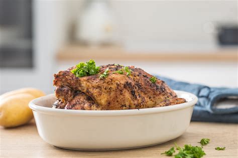 흰 접시에 구운 통 닭고기와 생 감자를 키치 테이블에 올려놓았다 배경의 홈 인테리어 0명에 대한 스톡 사진 및 기타 이미지