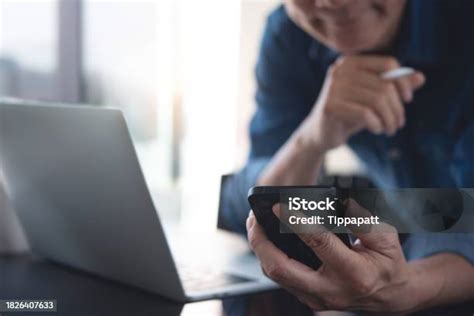 휴대 전화를 사용하고 사무실 테이블에 디지털 태블릿이있는 랩톱 컴퓨터에서 작업하는 아시아 캐주얼 비즈니스 맨의 클로즈업 55 59세에 대한 스톡 사진 및 기타 이미지