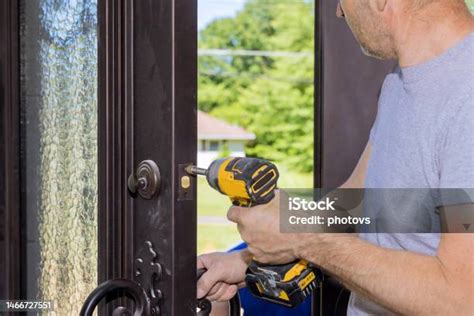 새 집을 짓는 동안 목수 작업자가 현관 문에 새 자물쇠를 설치합니다 55 59세에 대한 스톡 사진 및 기타 이미지 55 59세 가정 생활 강철 Istock