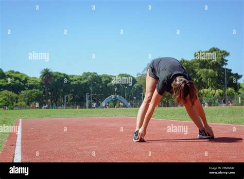 Young Latina Woman Of Argentinian Ethnicity Stretching On The Running