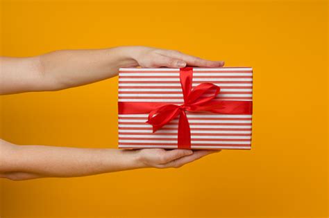 노란 배경에 빨간 리본으로 선물 상자를 들고 있는 여성의 손 노랑에 대한 스톡 사진 및 기타 이미지 노랑 놀라움 배경 주제 Istock